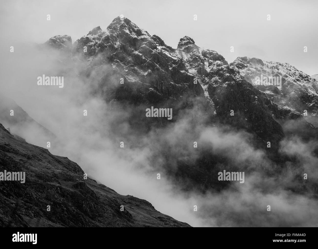 The Aonach Eagach ridge smouldering with low lying cloud as the exposed ...
