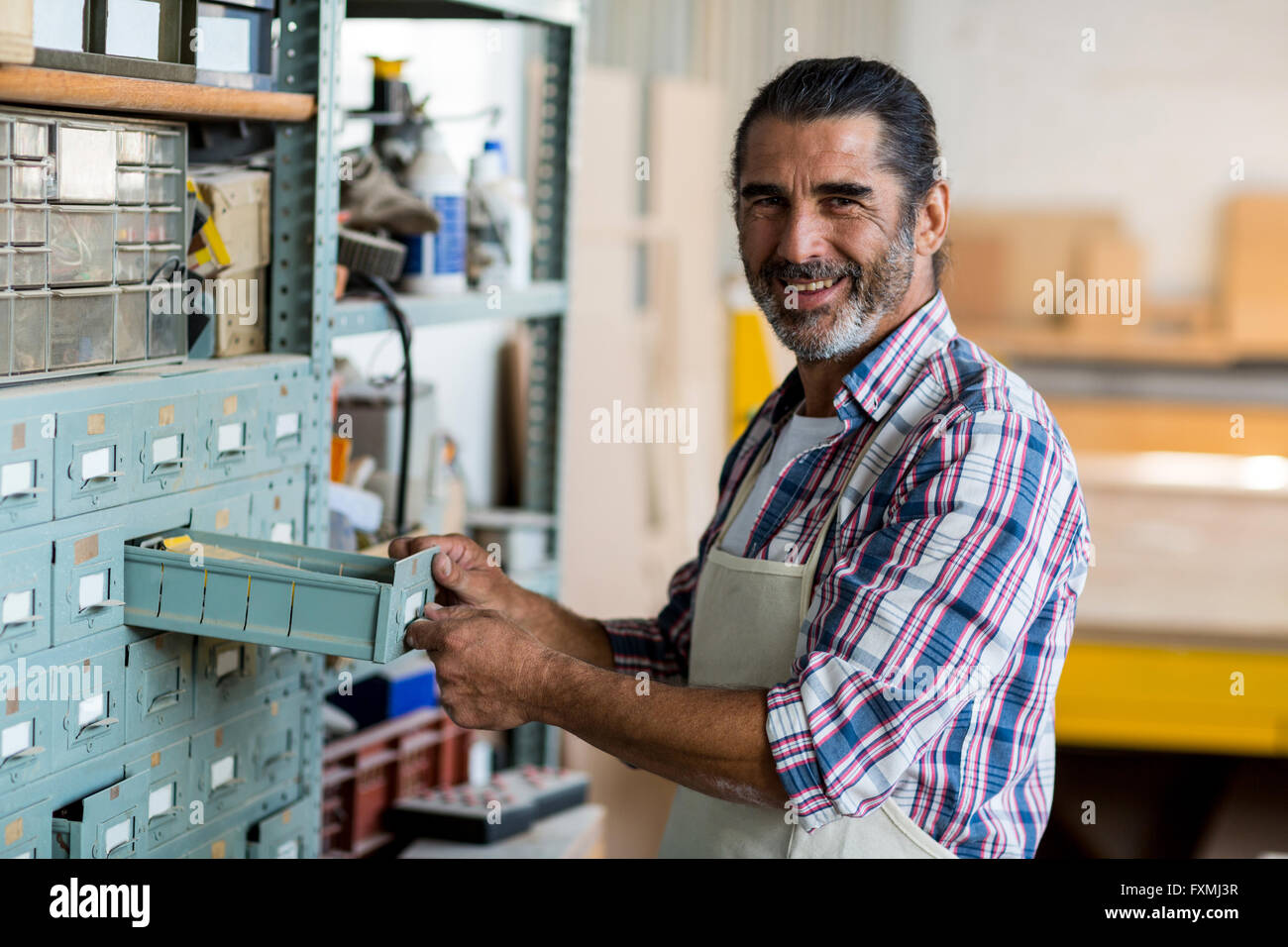 Carpenter picking up a tool from drawer Stock Photo - Alamy