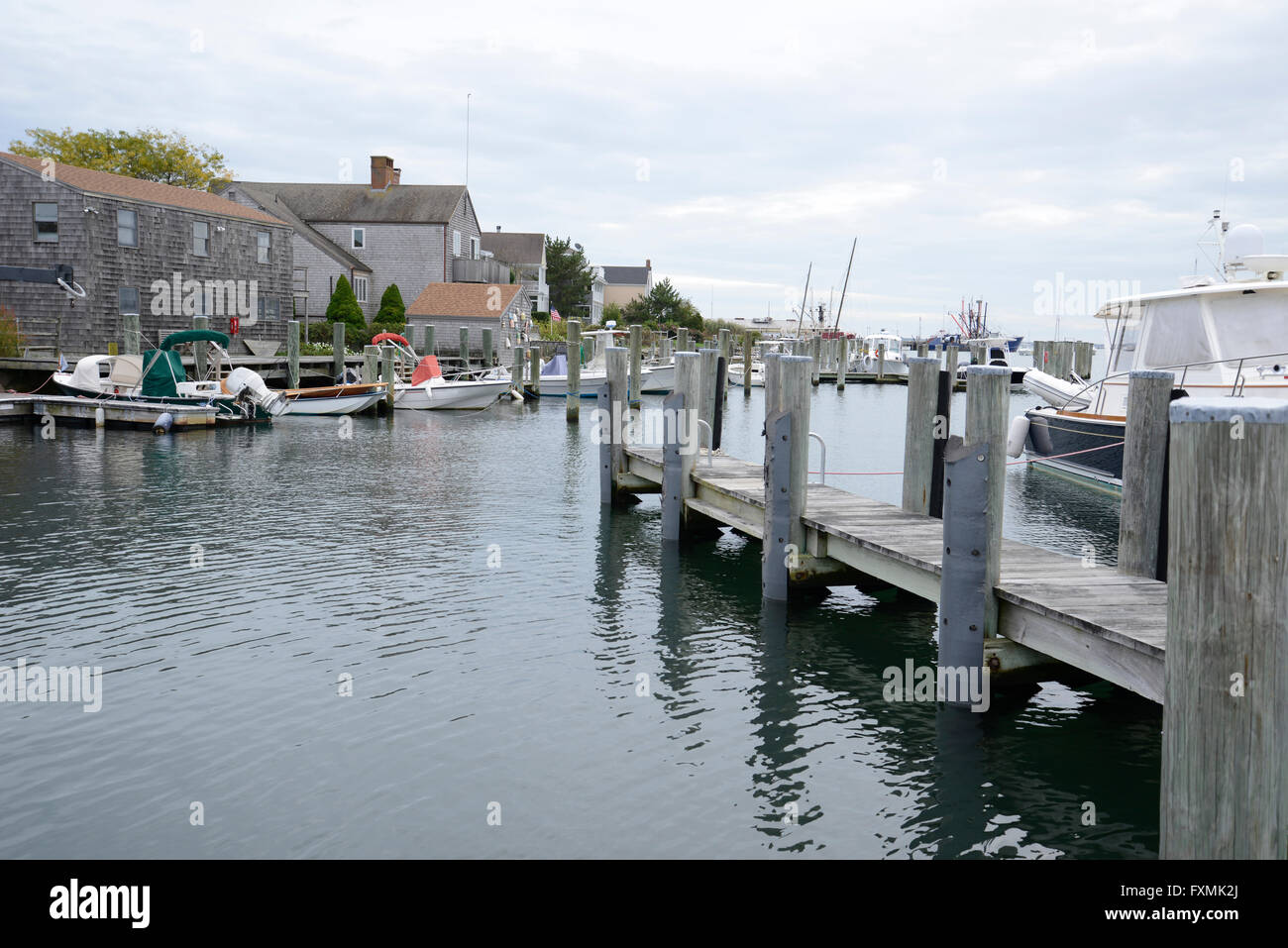 several docked boats by a wooden pier in a harbor in Stonington ...