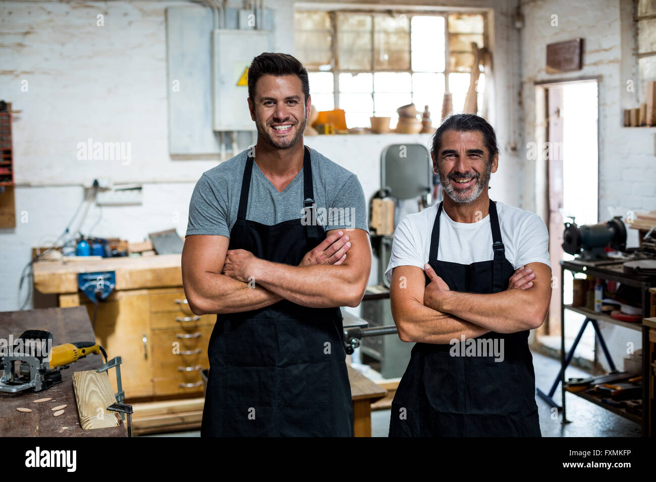 Two carpenters standing with arm crossed Stock Photo - Alamy