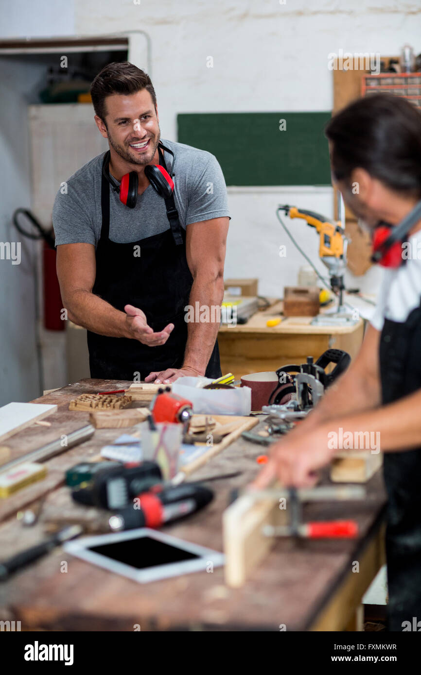 Carpenters interacting with each other Stock Photo - Alamy