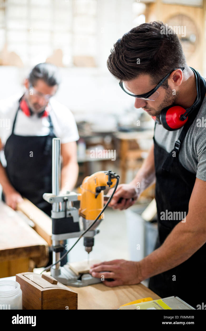 Carpenter drilling a hole in a wooden plank Stock Photo - Alamy