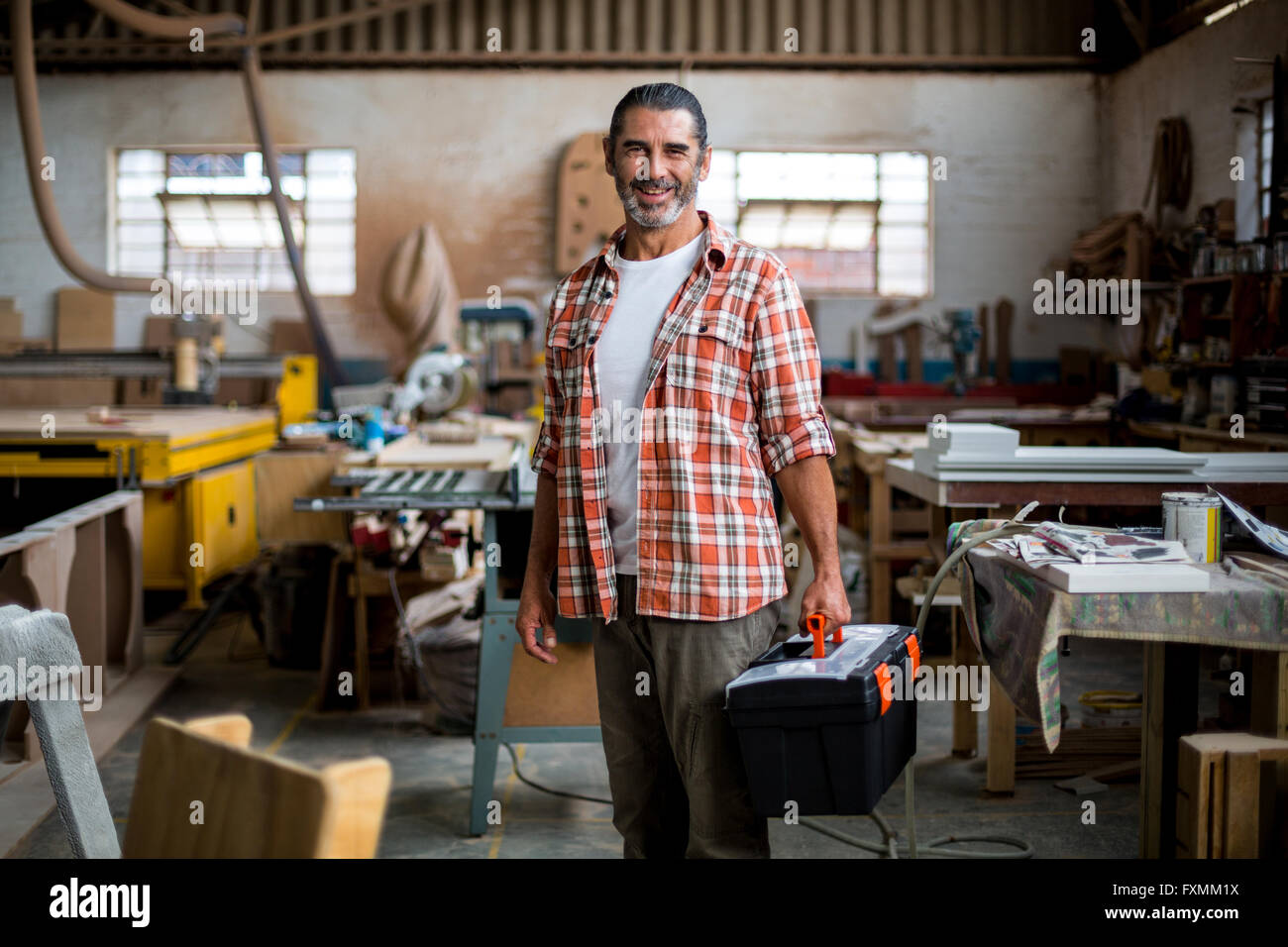 Portrait of carpenter standing with tool box Stock Photo - Alamy
