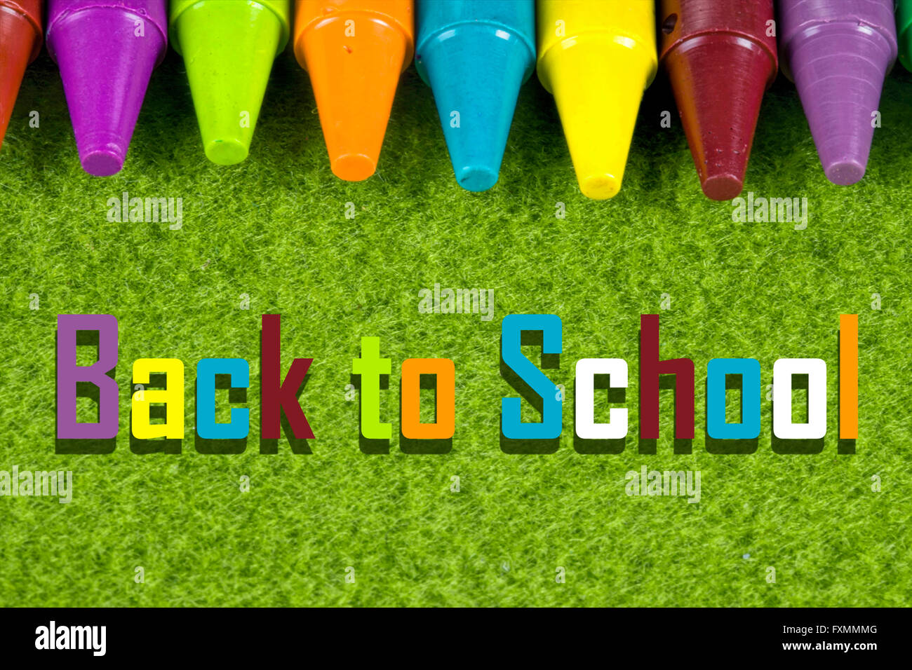 Back to school theme with colorful pastel crayons on green background ...