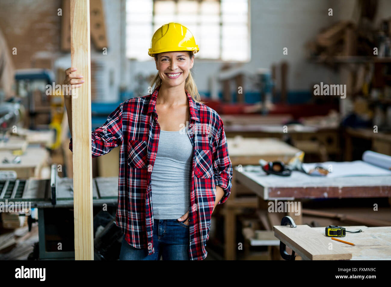 Portrait of female carpenter standing with wooden plank Stock Photo - Alamy