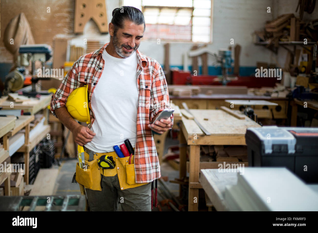 Carpenter text messaging on mobile phone Stock Photo - Alamy