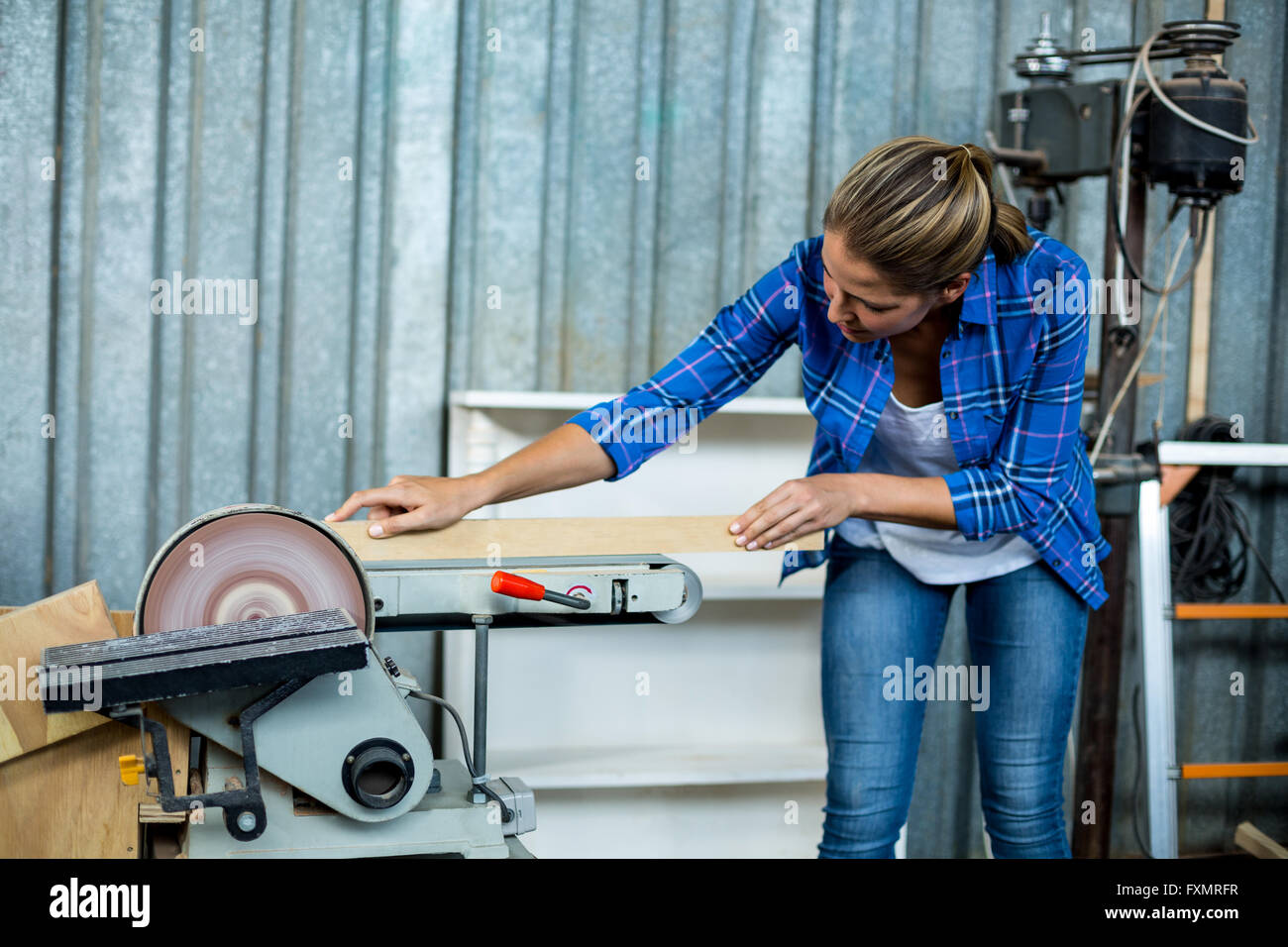Female carpenter working with sanding machine Stock Photo - Alamy