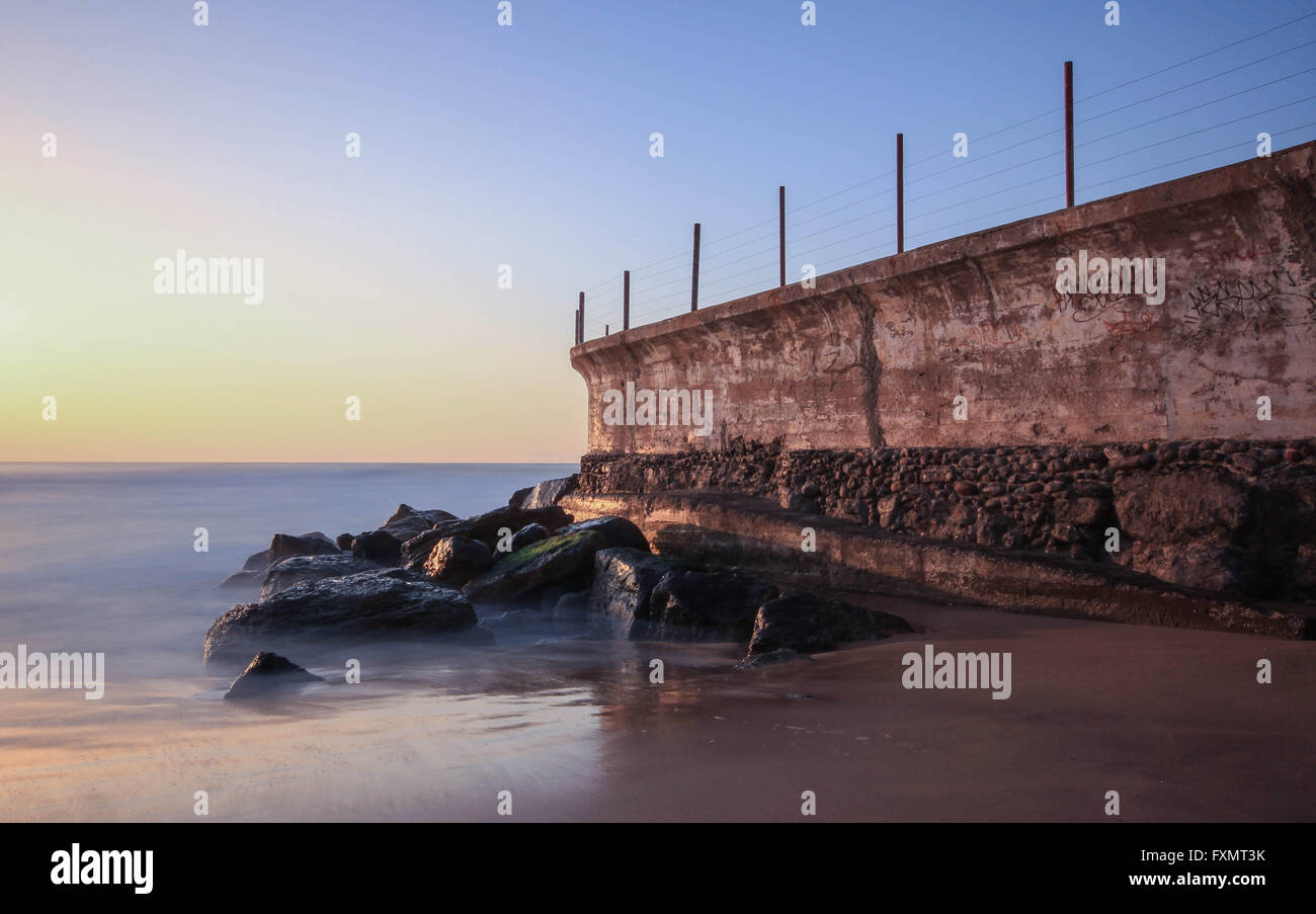 Stone jetty on praia grande beachfront at sunset Stock Photo - Alamy