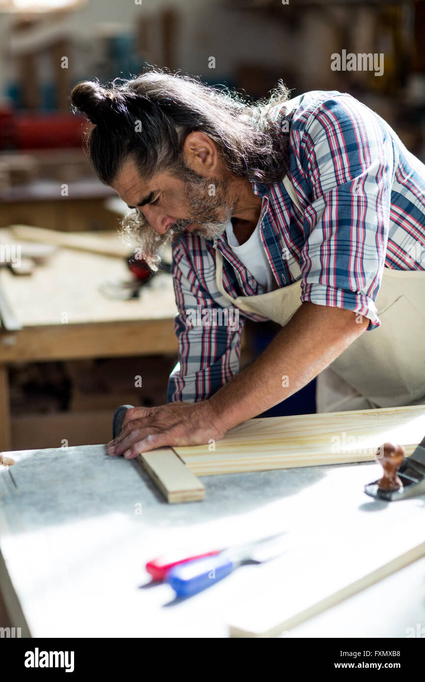 Male carpenter measuring wooden plank Stock Photo - Alamy