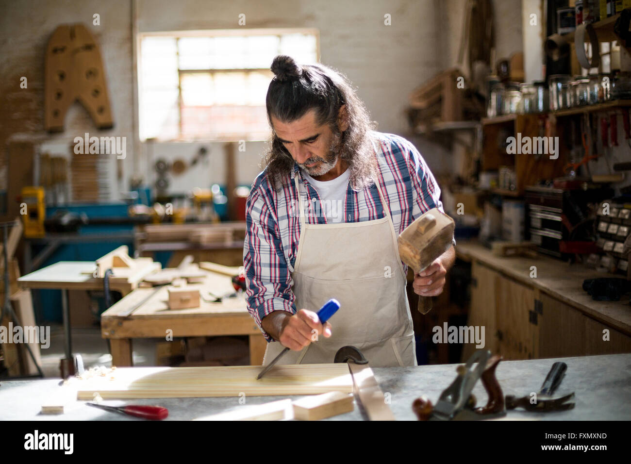 Carpenter using mallet and chisel Stock Photo - Alamy