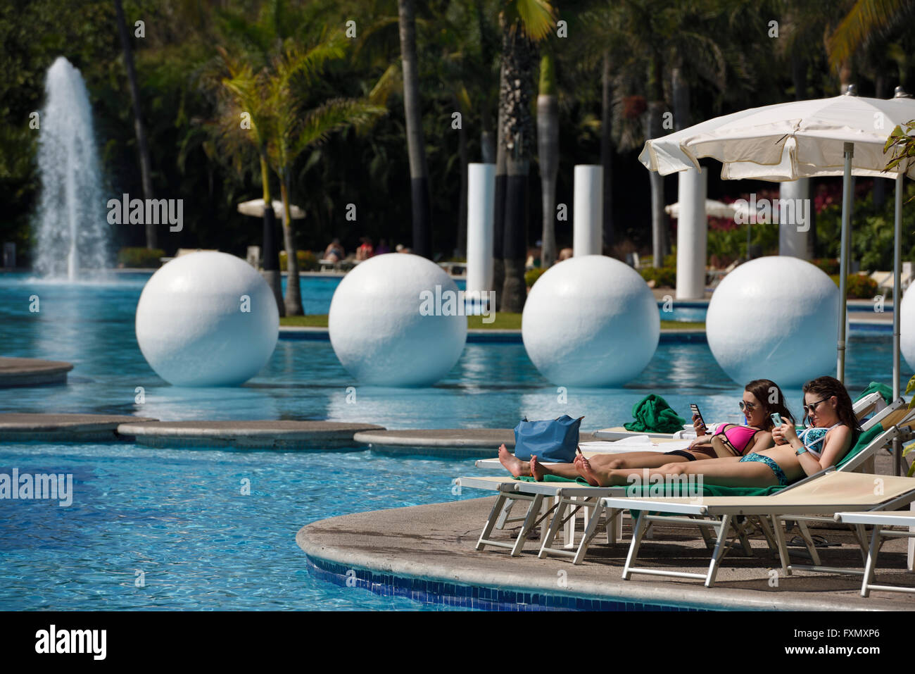 Two women by pool lounge chairs hi-res stock photography and images - Alamy