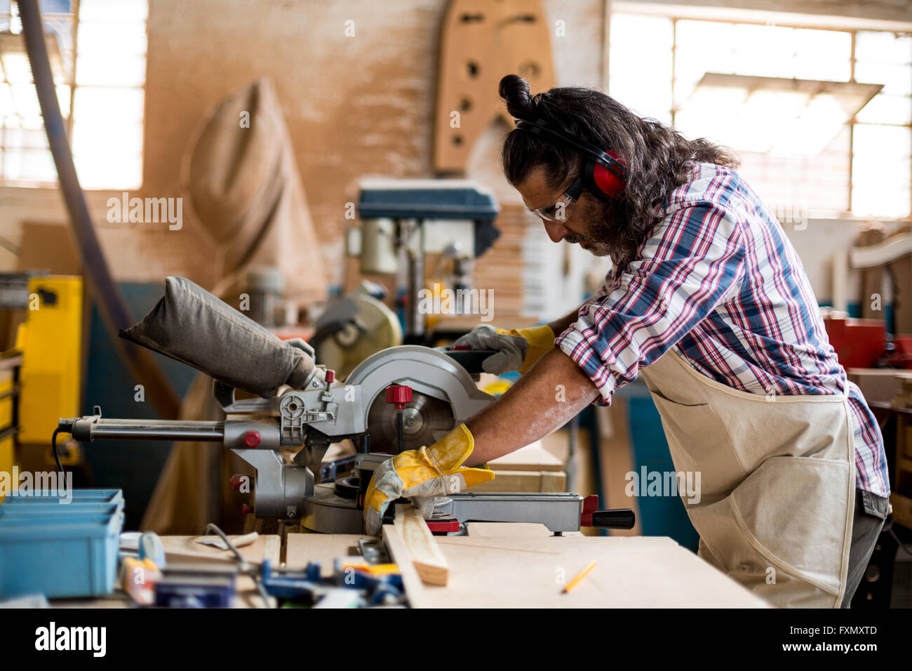Carpenter cutting wooden plank with circular saw Stock Photo - Alamy
