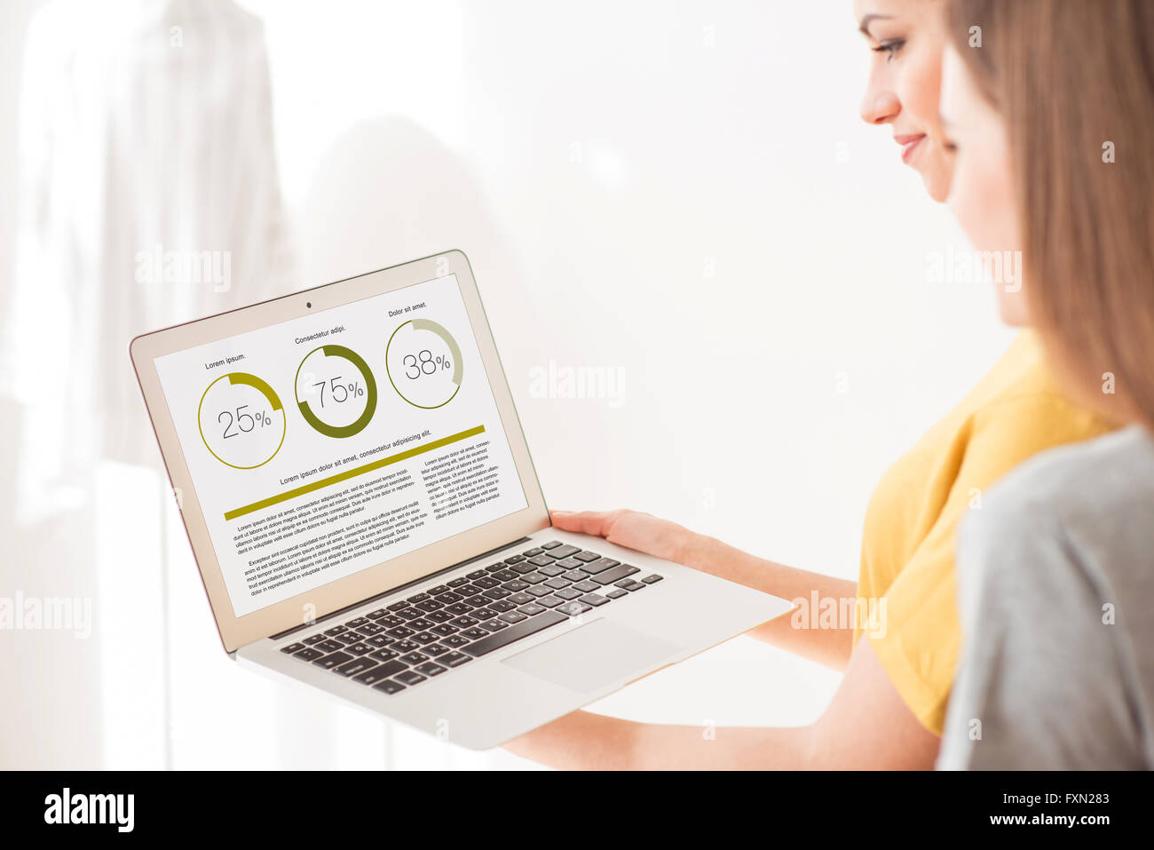 Positive girls holding laptop Stock Photo - Alamy