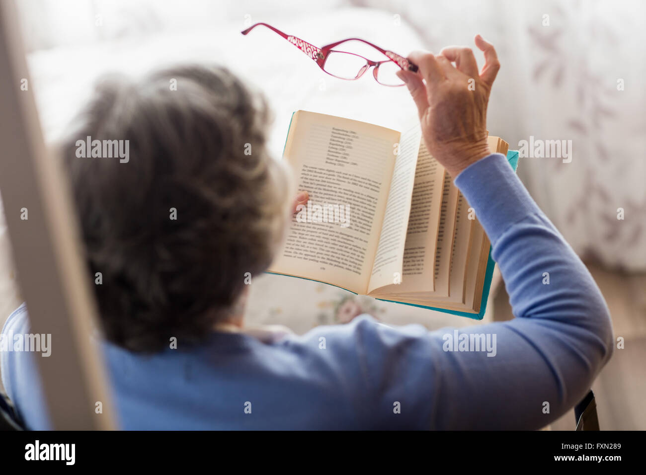 Senior woman reading a book Stock Photo - Alamy