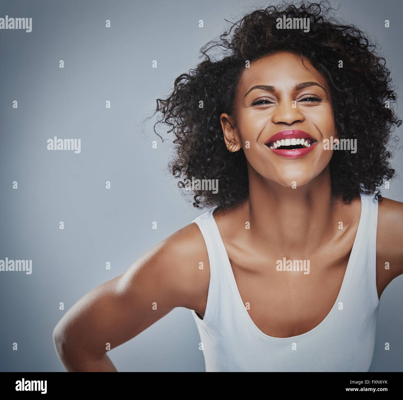 Single laughing young Black adult female in sleeveless undershirt with ...