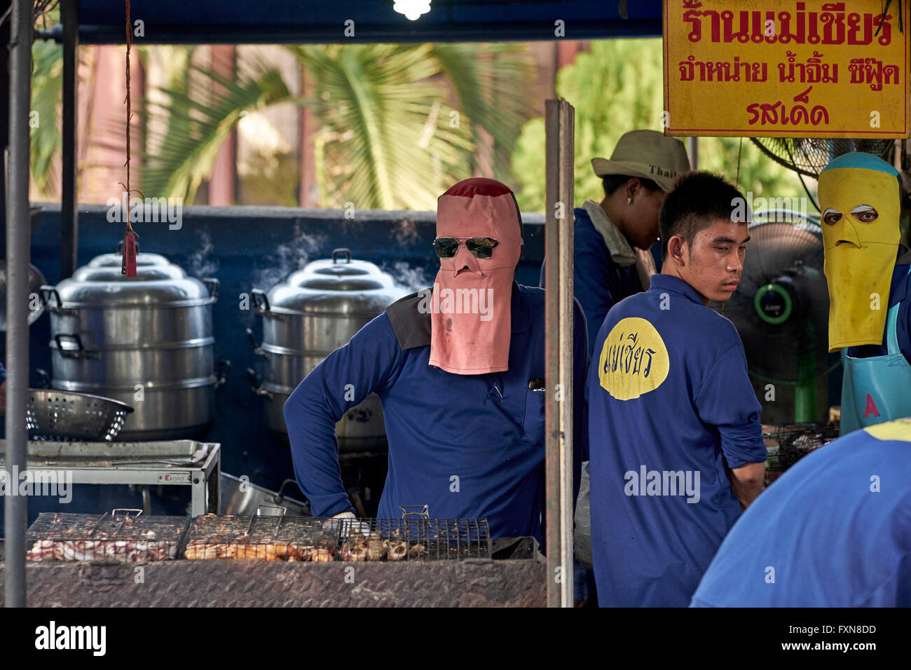 Face mask. Chef cooking at an outdoor market BBQ stall and wearing full ...