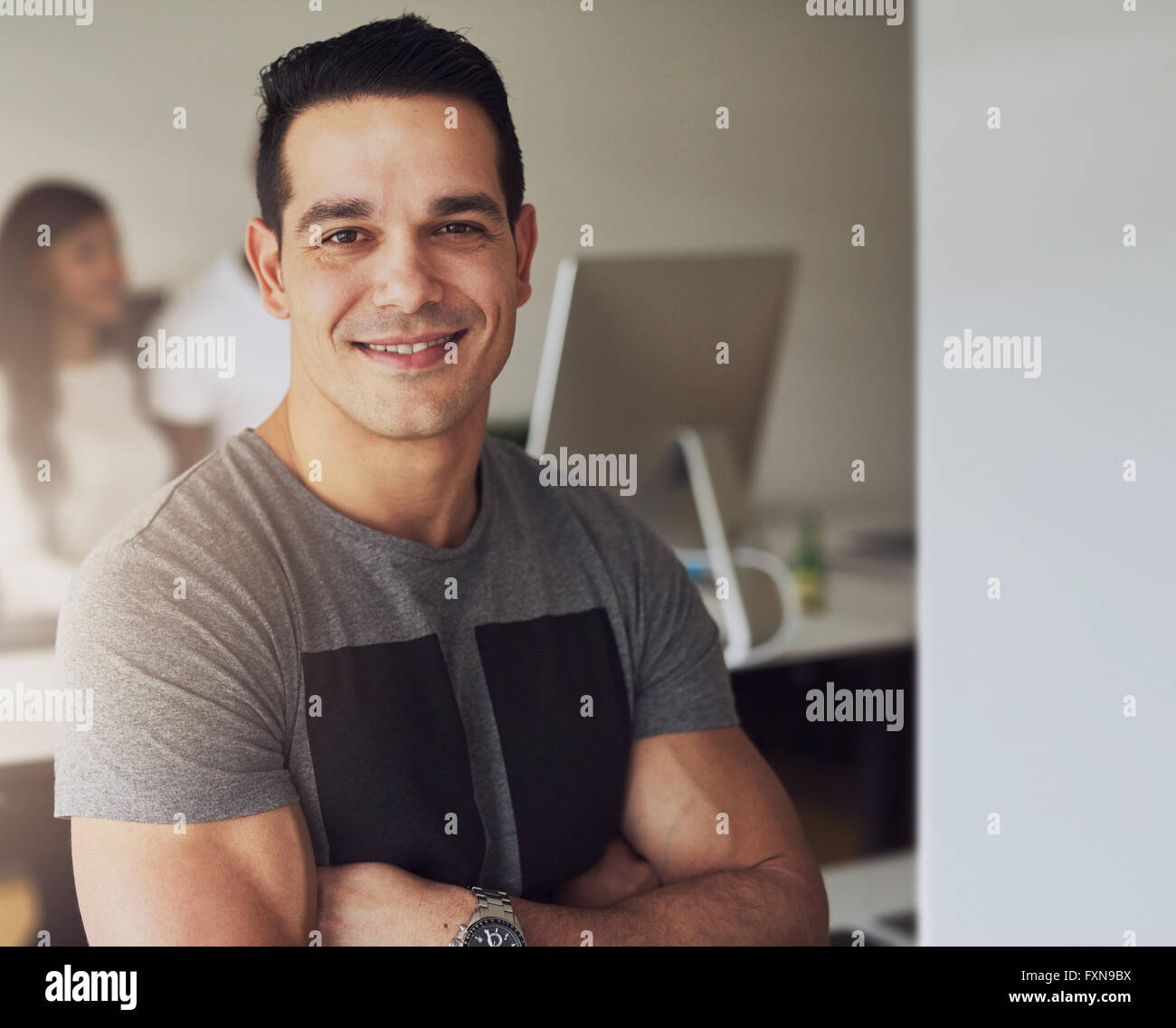 Close up of confident handsome male worker with folded muscular arms ...