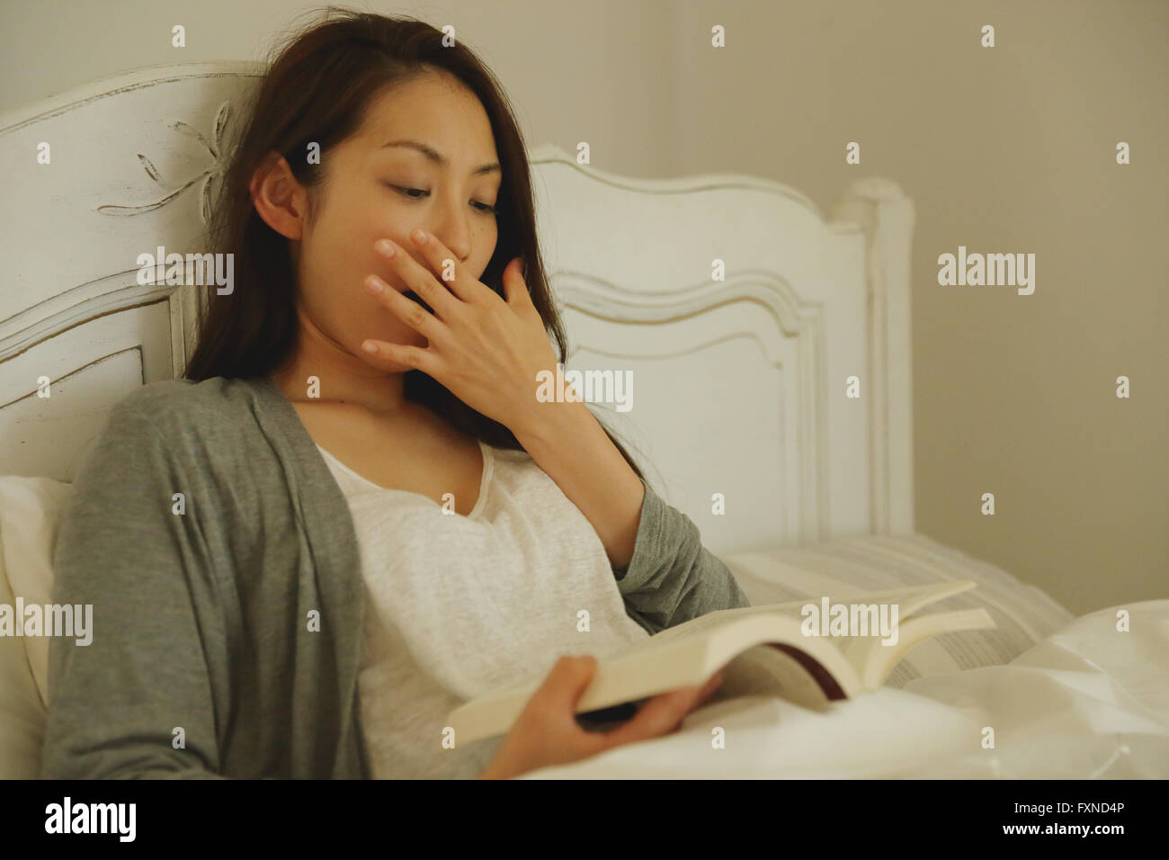 Young attractive Japanese woman reading in bed Stock Photo - Alamy