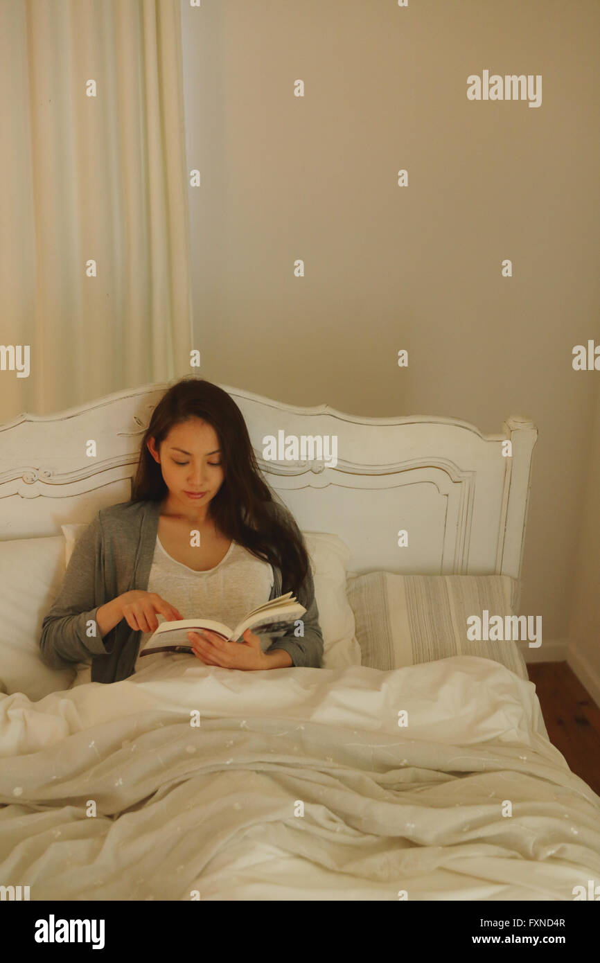 Young attractive Japanese woman reading in bed Stock Photo - Alamy