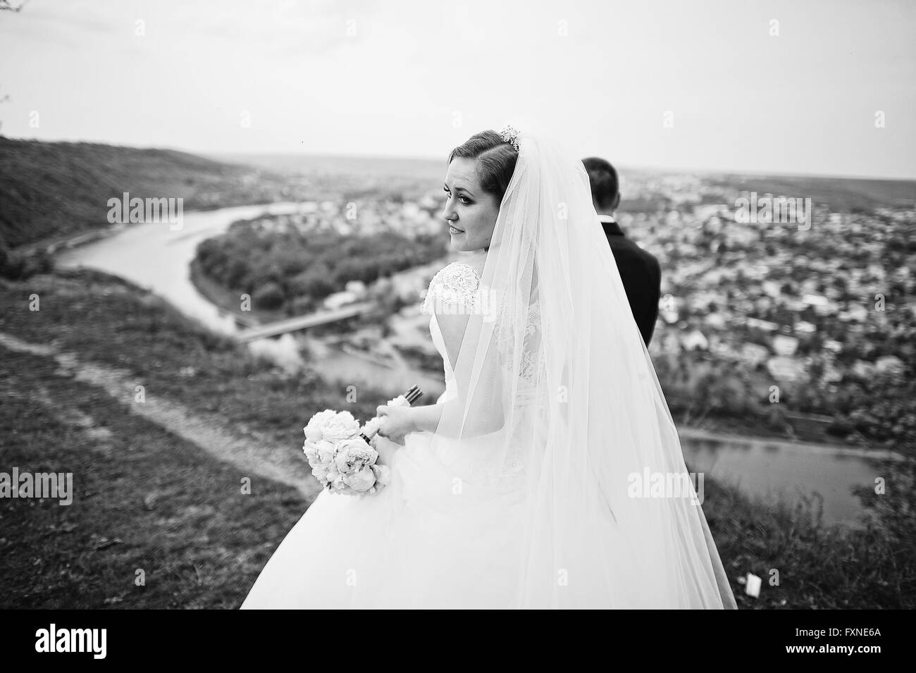 View of back gorgeous bride walking with groom, b&w photo Stock Photo ...