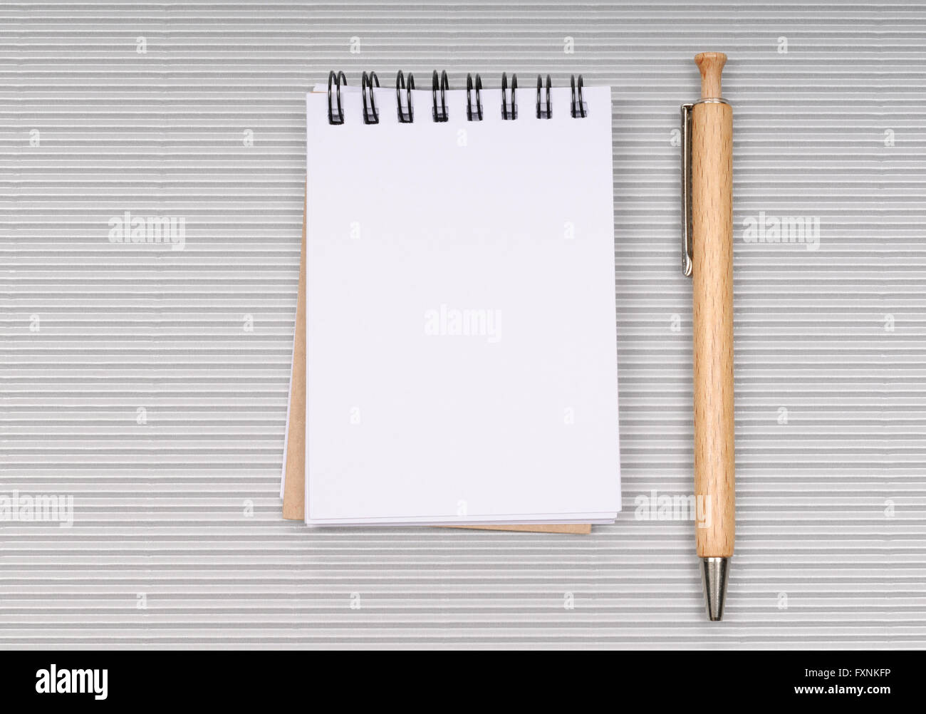 Notepad and a pen out of wood on silver corrugated cardboard Stock ...