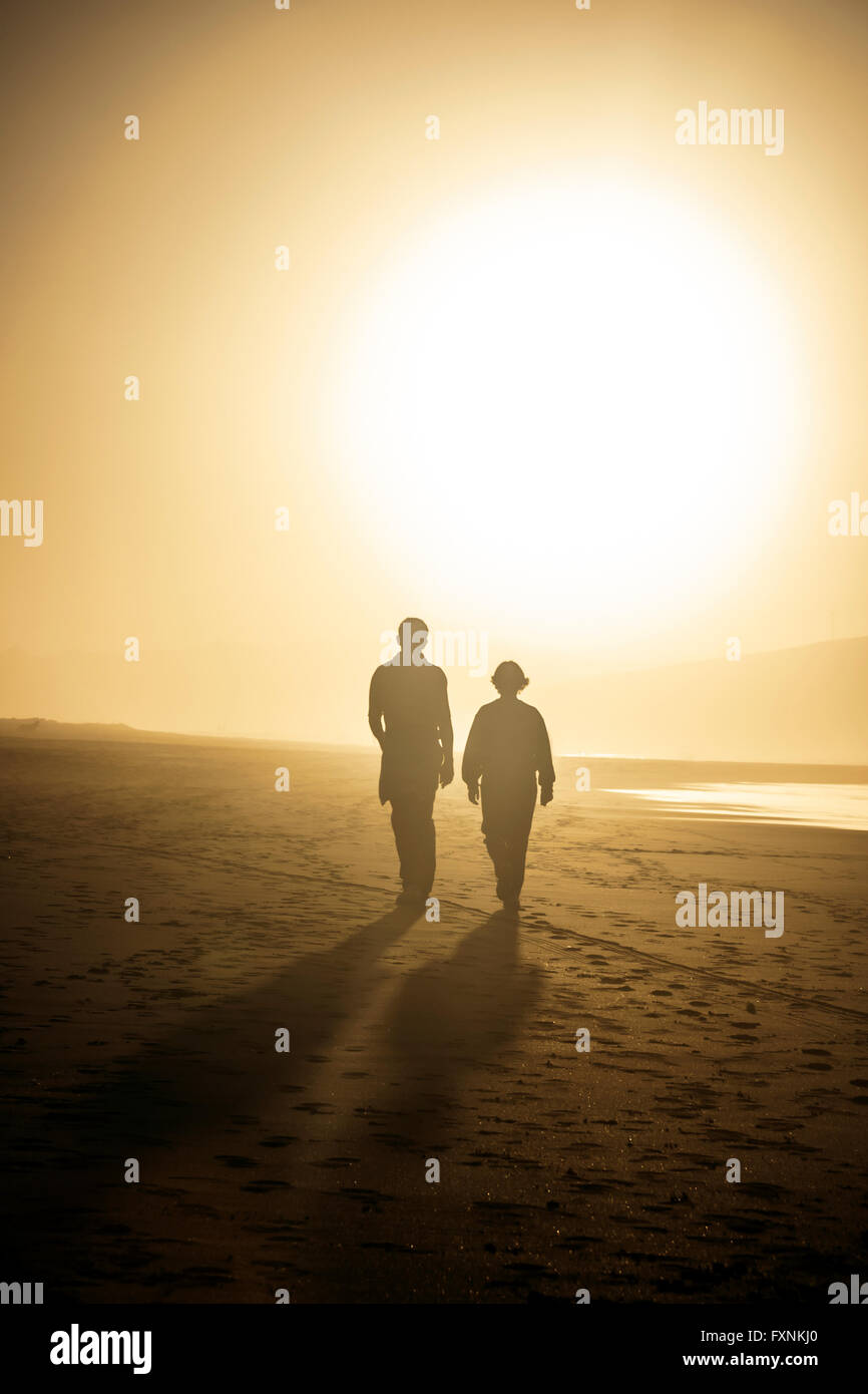 TWO PEOPLE WALKING TO THE SUN Stock Photo - Alamy