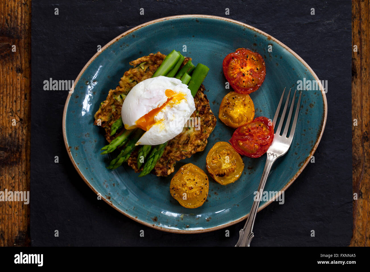 Courgette rosti, poached egg, asparagus and roast tomatoes Stock Photo ...