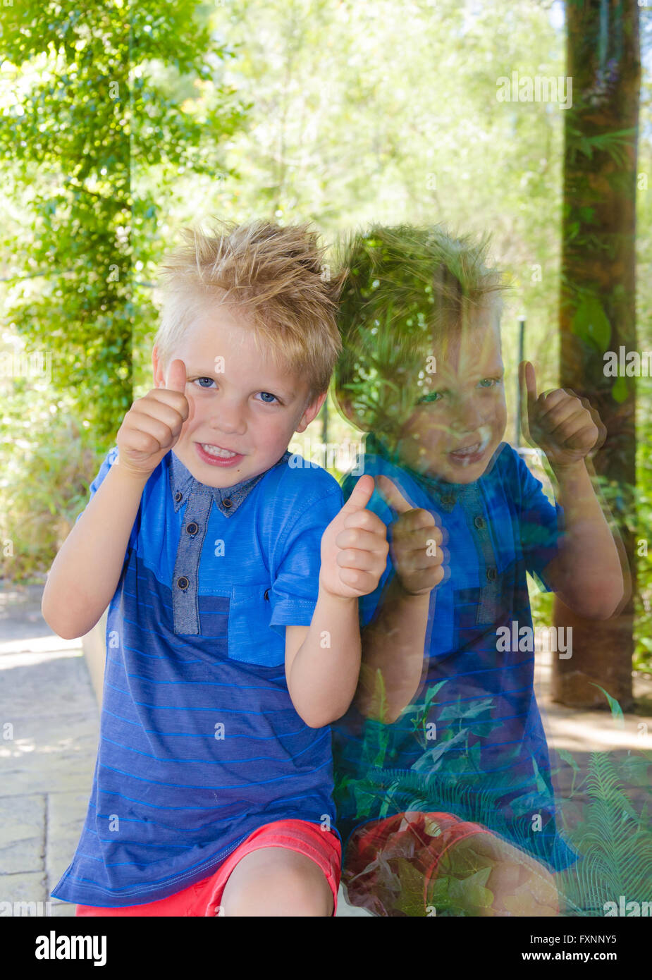 Beautiful little boy smiling next to a window Stock Photo - Alamy