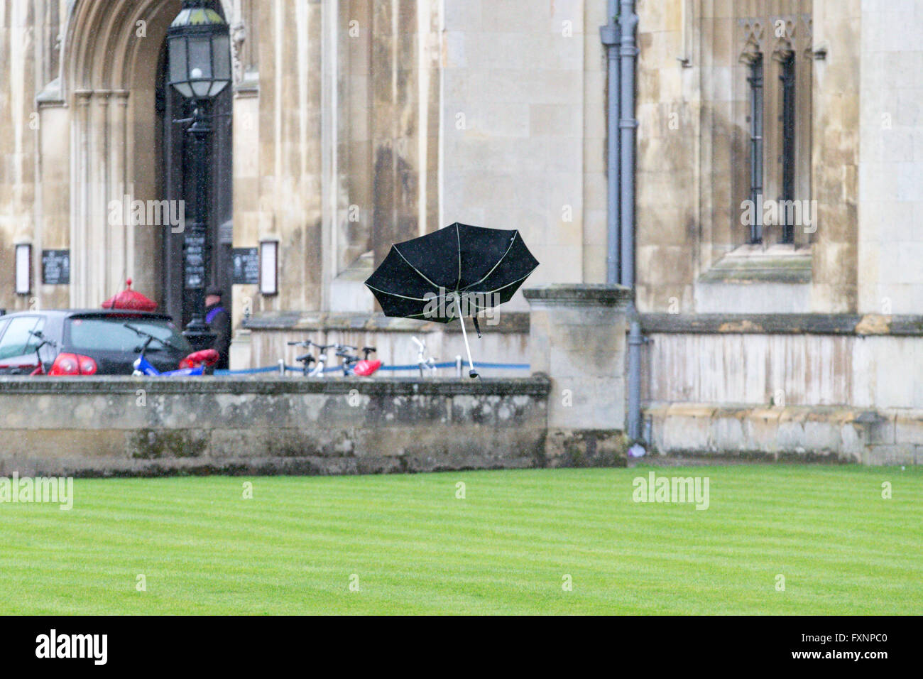 Tourists Cambridge under umbrellas in bad weather whilst walking and ...