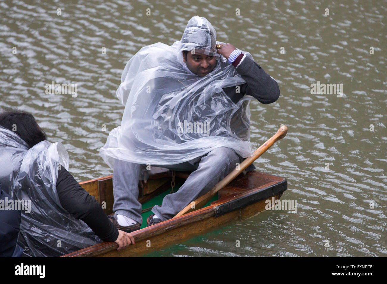 Tourists Cambridge under umbrellas in bad weather whilst walking and ...
