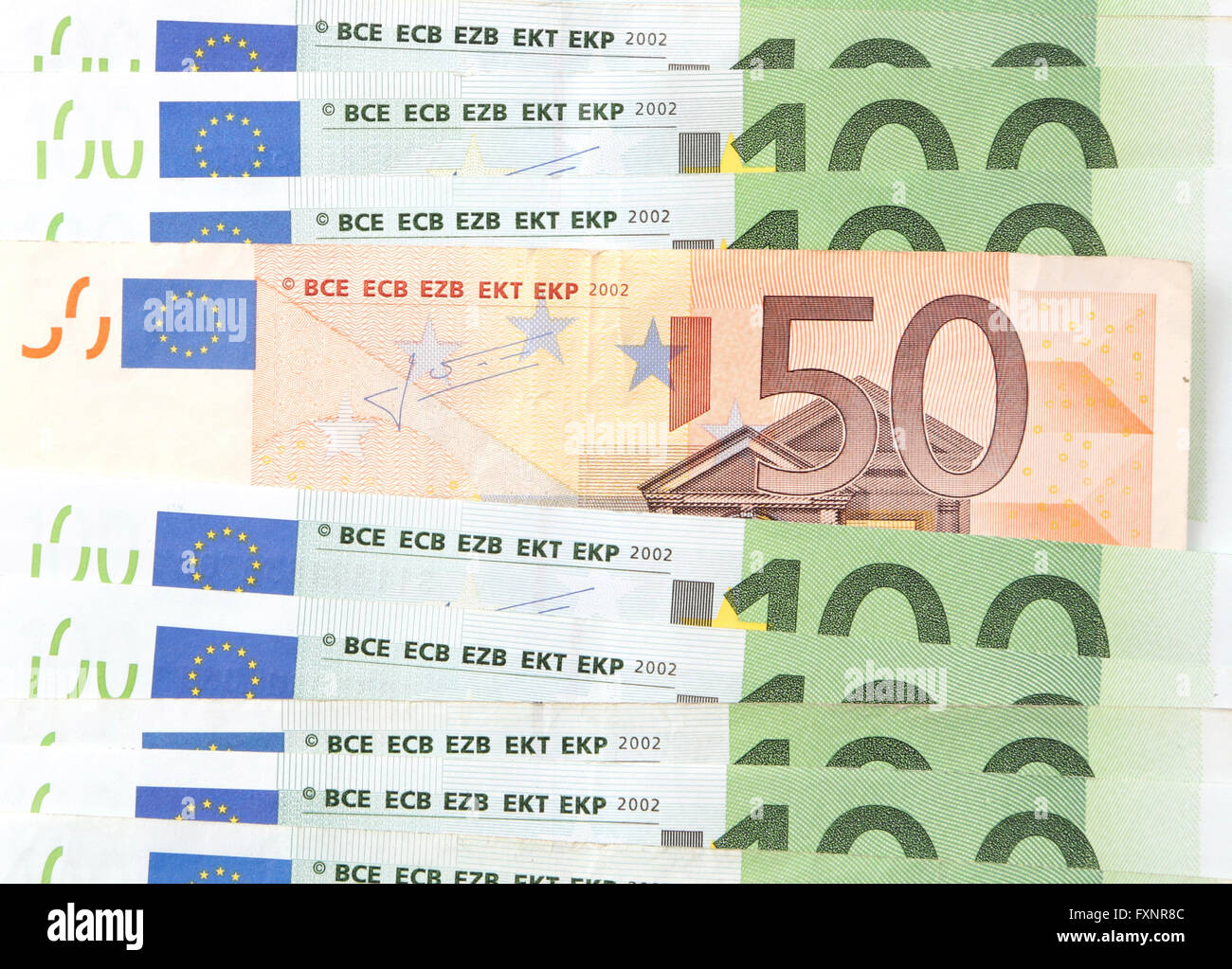 A fifty euro note between many hundred euro notes Stock Photo - Alamy