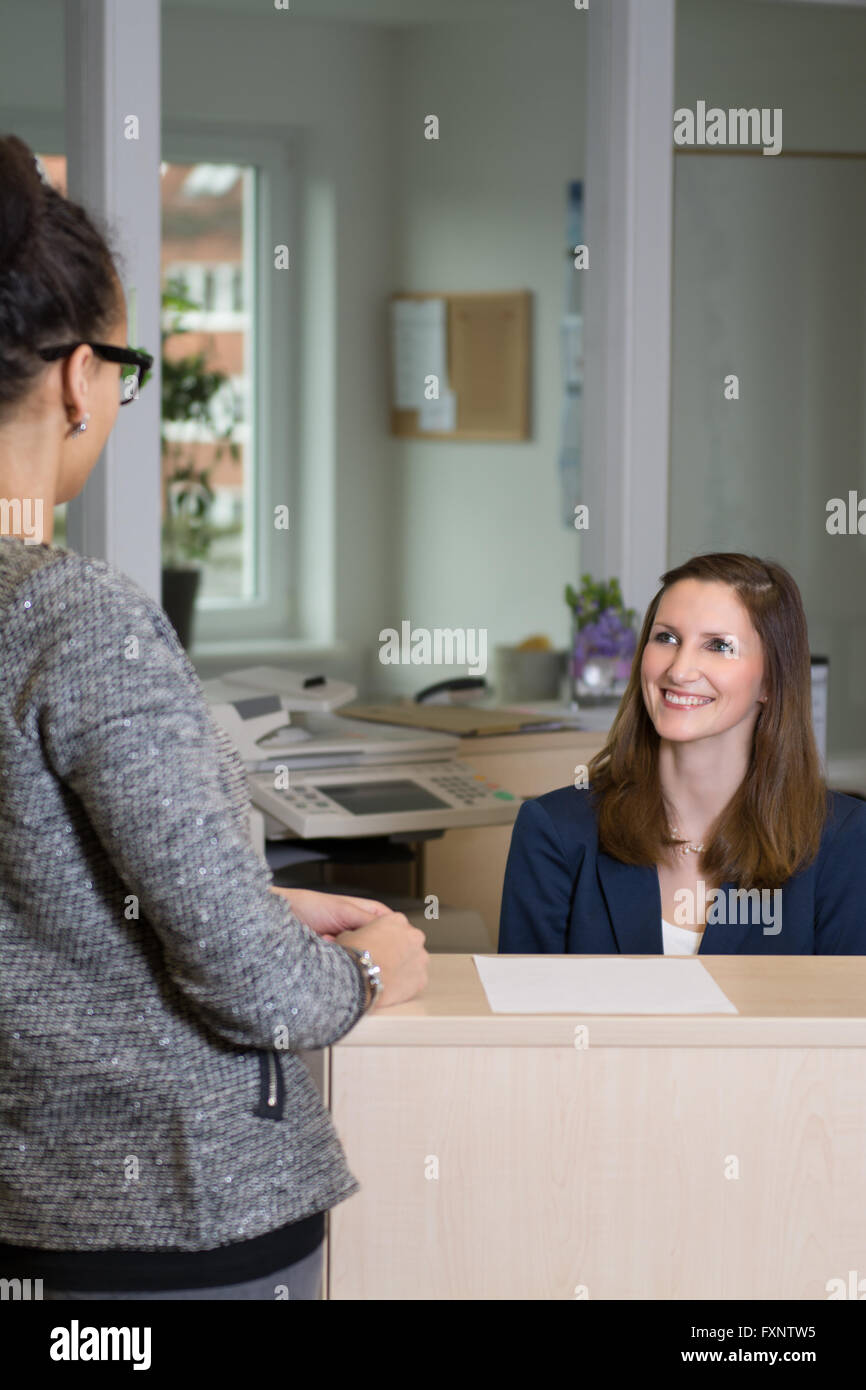 Woman behind office reception desk hi-res stock photography and images ...
