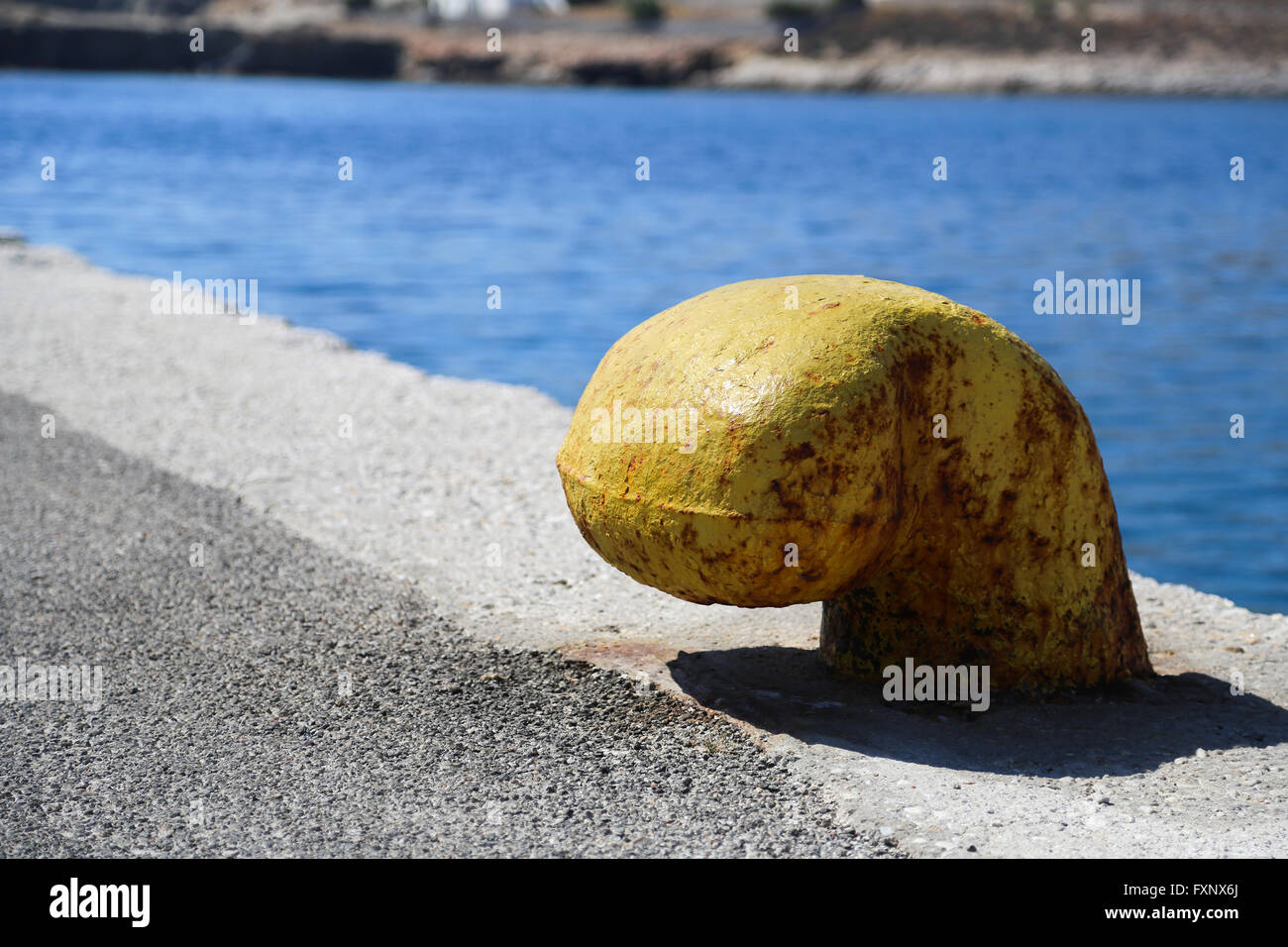 Empty metal yellow bollard at the harbor Stock Photo - Alamy