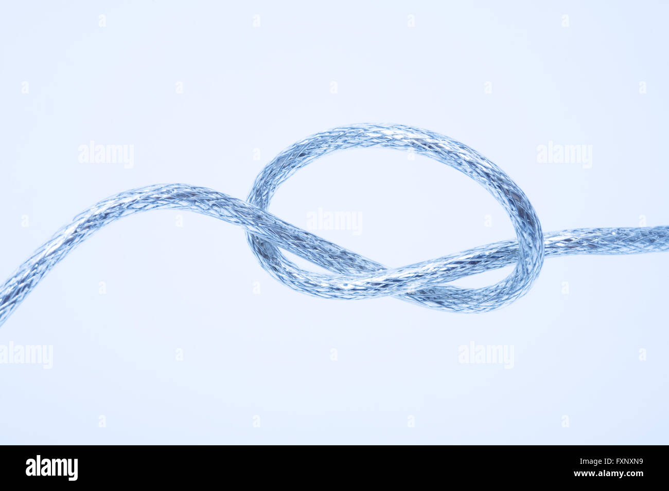 Wire fastened in the knot on a blue background Stock Photo - Alamy