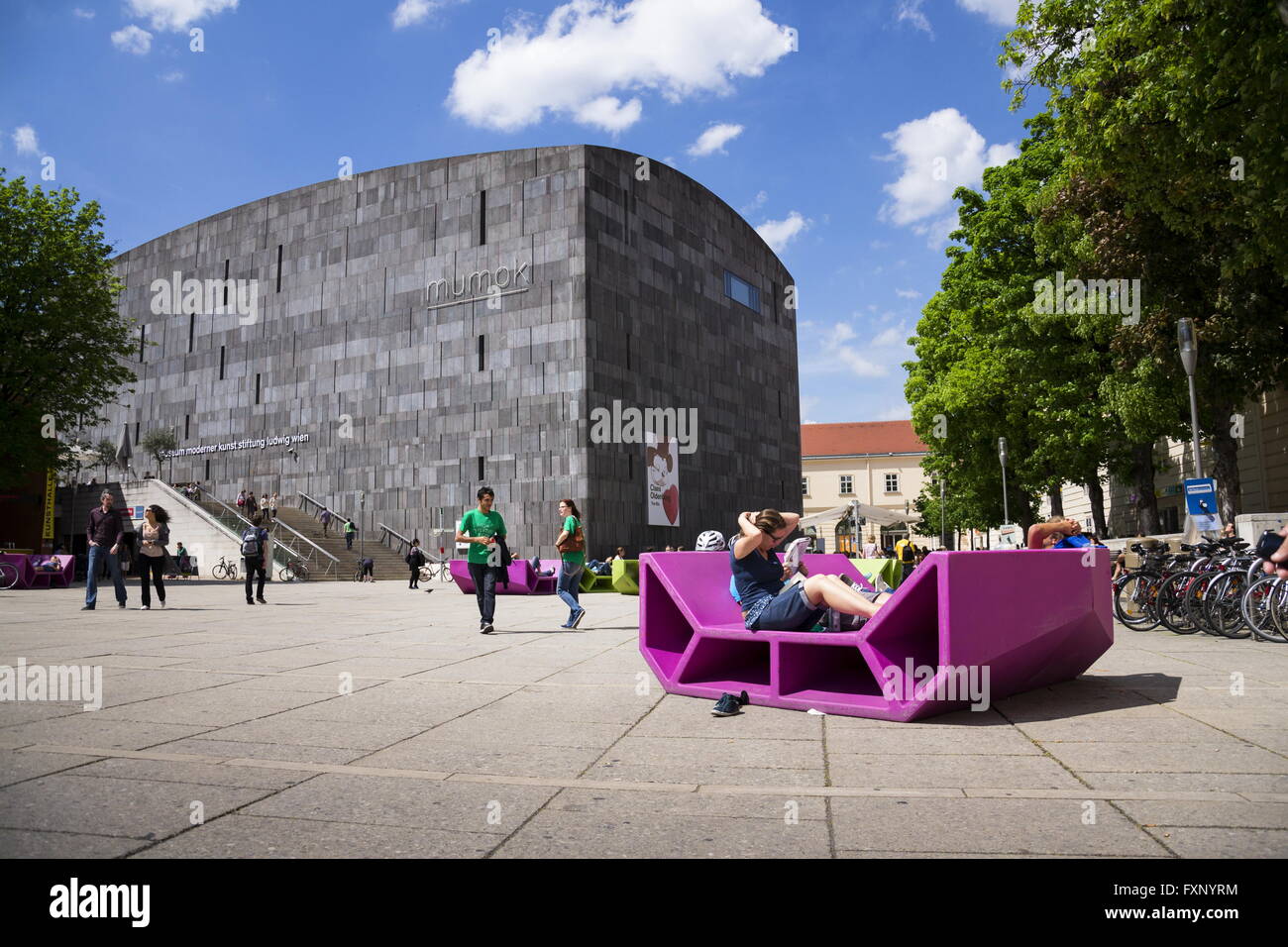 VIENNA, AUSTRIA - MAY 6: People rest on red benches in front of the ...