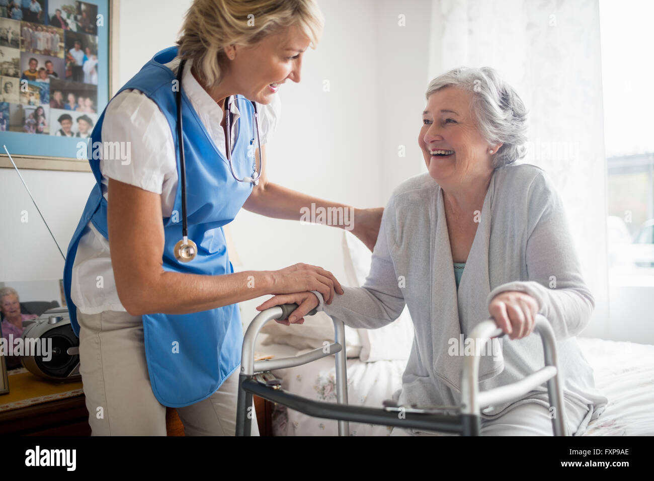 Nurse helping senior woman to stand up Stock Photo - Alamy