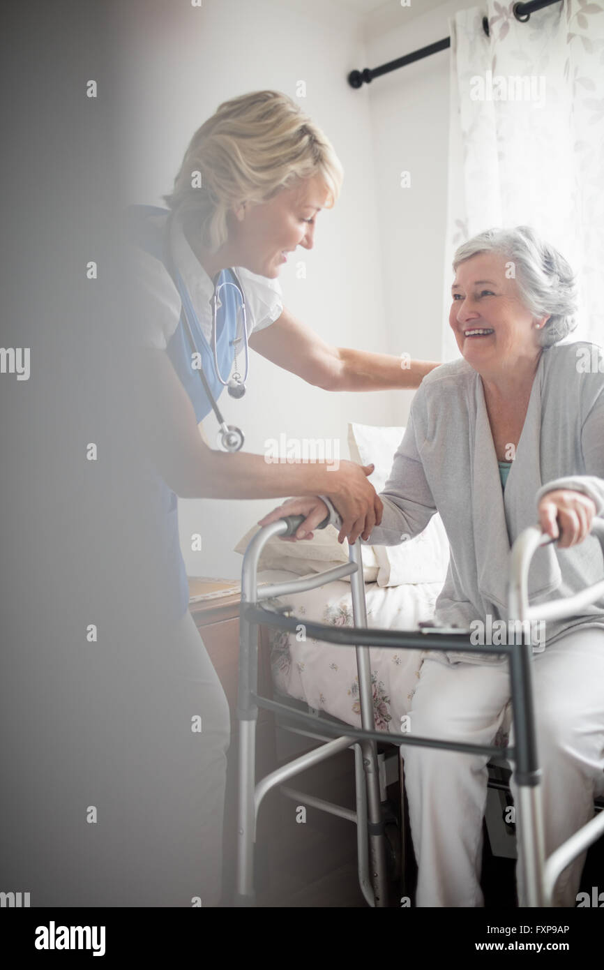 Nurse helping senior woman to stand up Stock Photo - Alamy