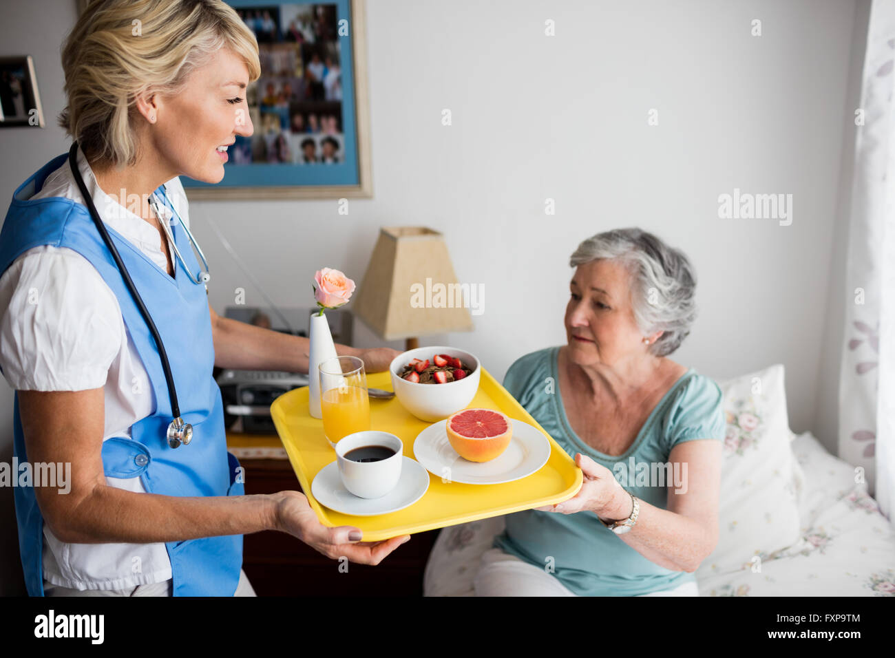 Nurse giving food to a senior woman in a retirement home Stock Photo ...