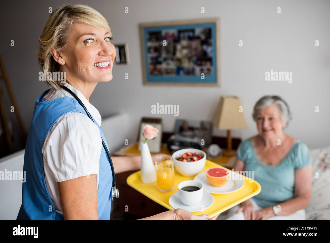 Nurse giving food to a senior woman Stock Photo - Alamy