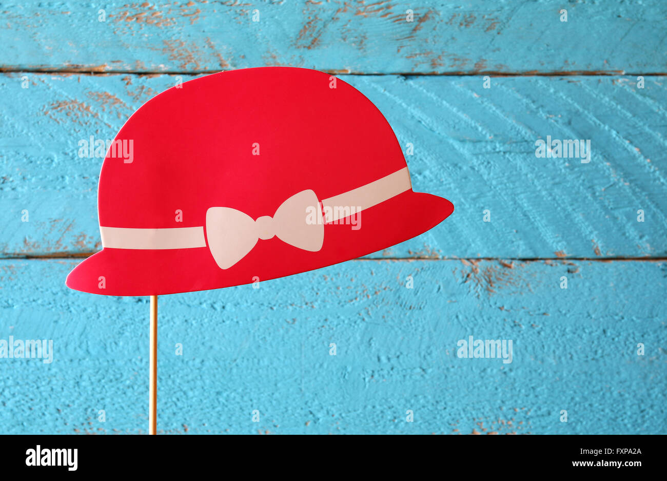 paper fake red hat in sticks in front of wooden background. vintage ...
