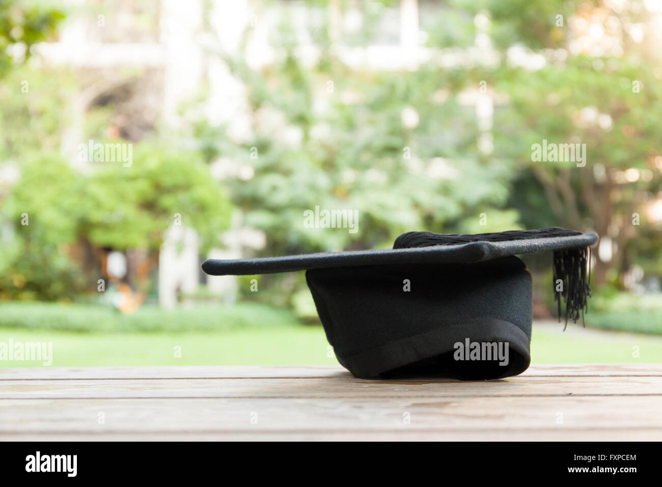 Graduation hat on vintage table with green nature background Stock ...