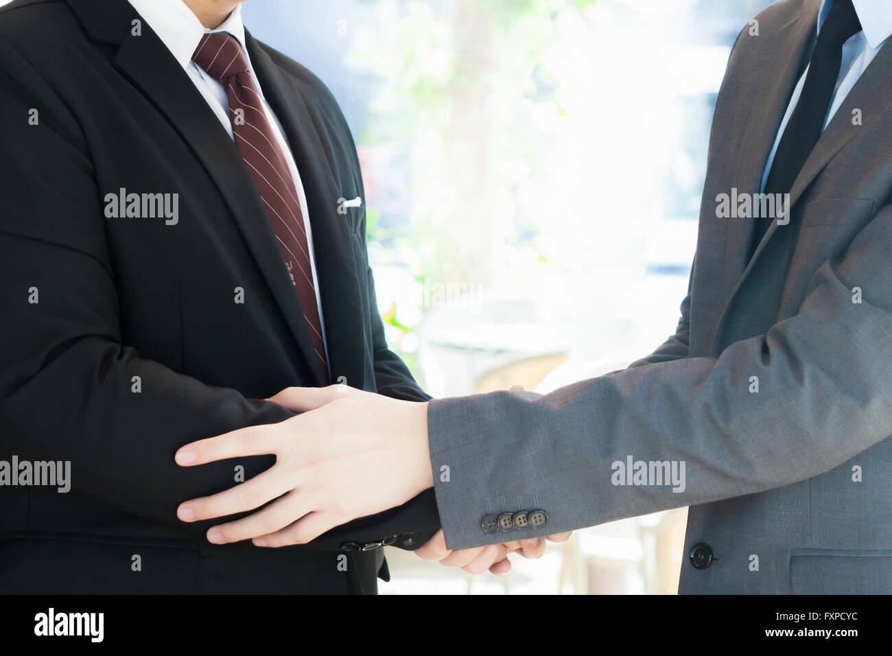 Two businessmen giving warm welcome, trust, teamwork, agreement to each ...