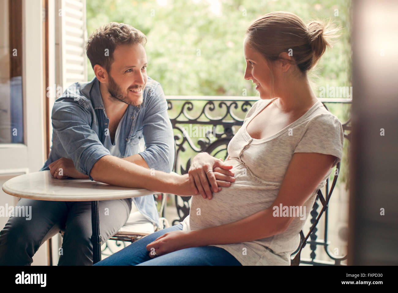 Husband resting hand on wife's pregnant stomach Stock Photo - Alamy