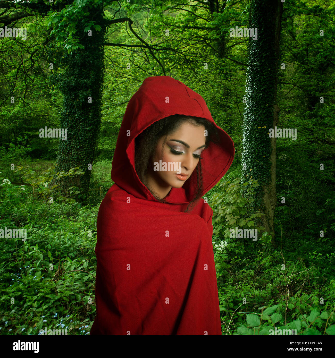 Sad young woman wearing a red cape outdoors Stock Photo - Alamy