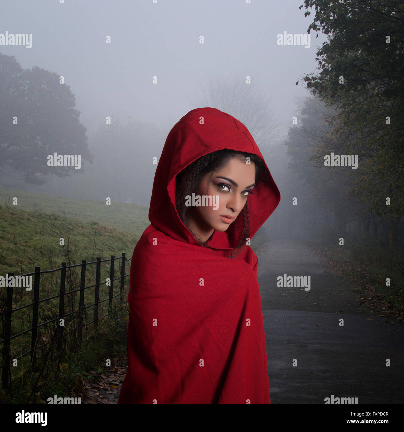 Sad young woman wearing a red cape outdoors Stock Photo - Alamy