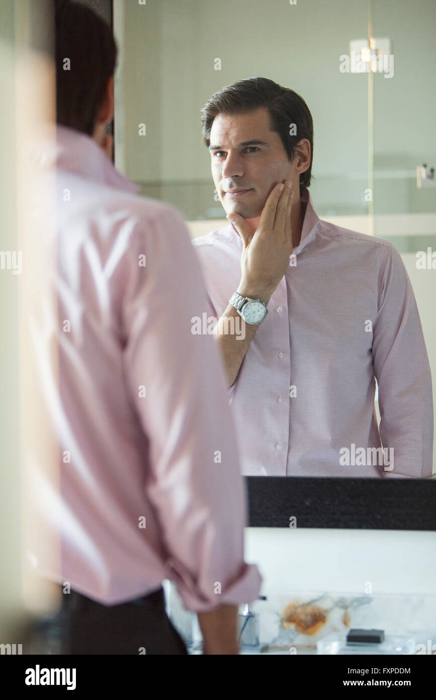 Man scrutinizing himself in mirror Stock Photo - Alamy