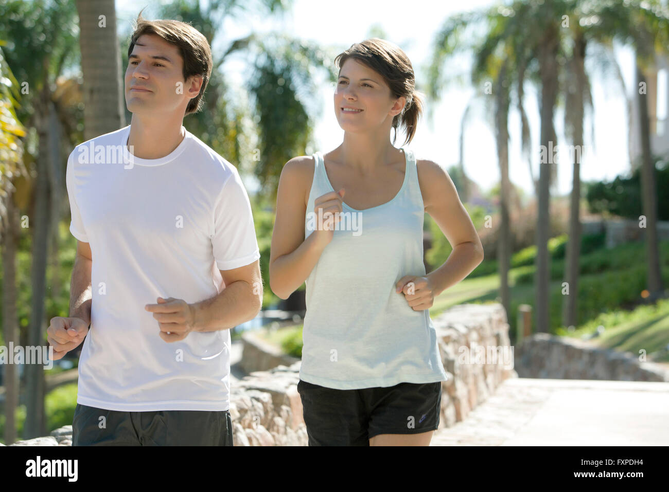 Couple jogging together in park Stock Photo - Alamy