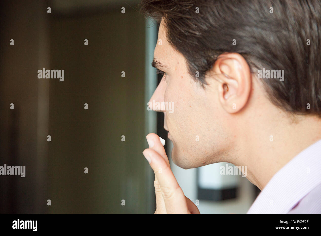 Man applying moisturizer to face Stock Photo - Alamy