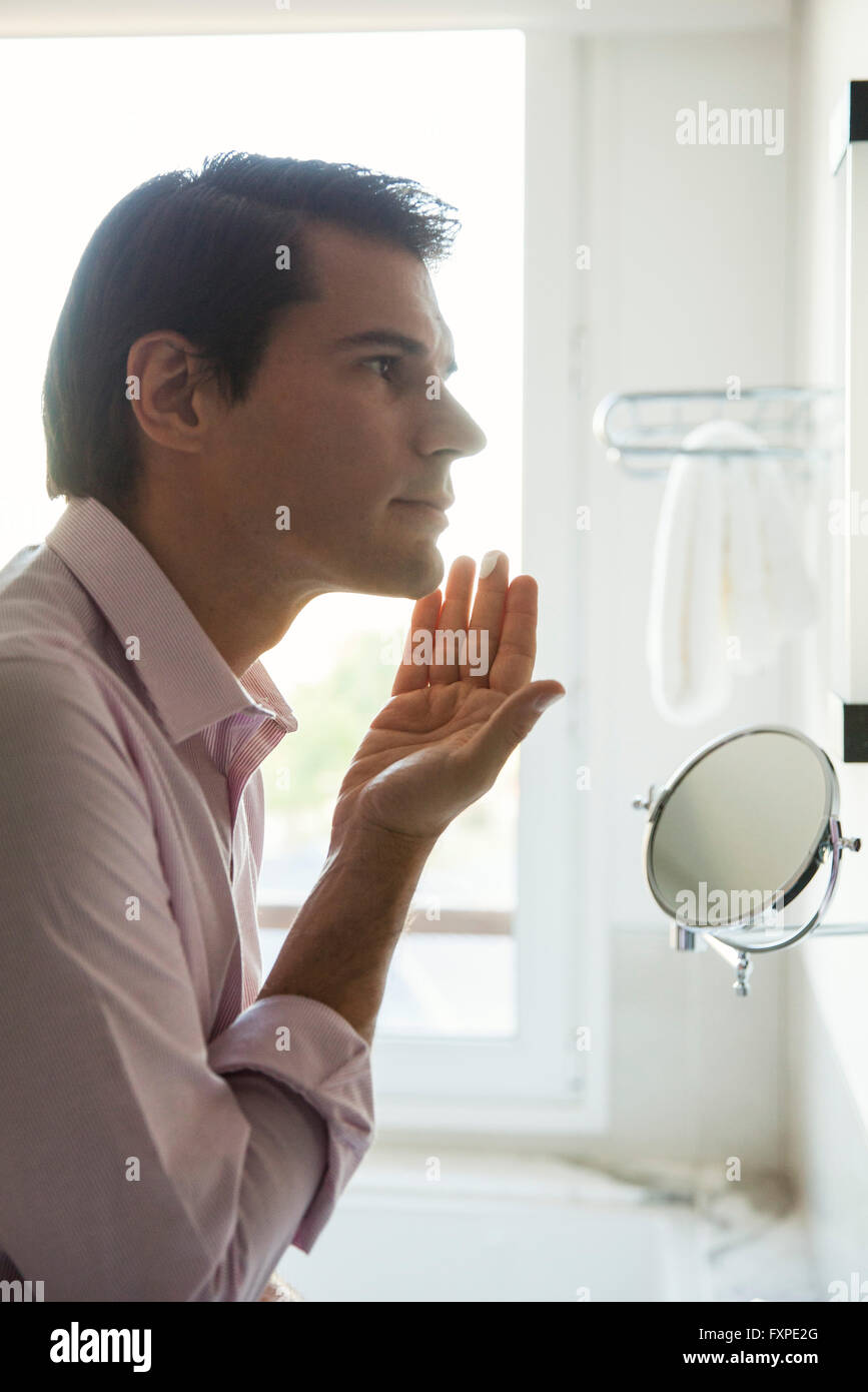 Man applying moisturizer to face Stock Photo - Alamy