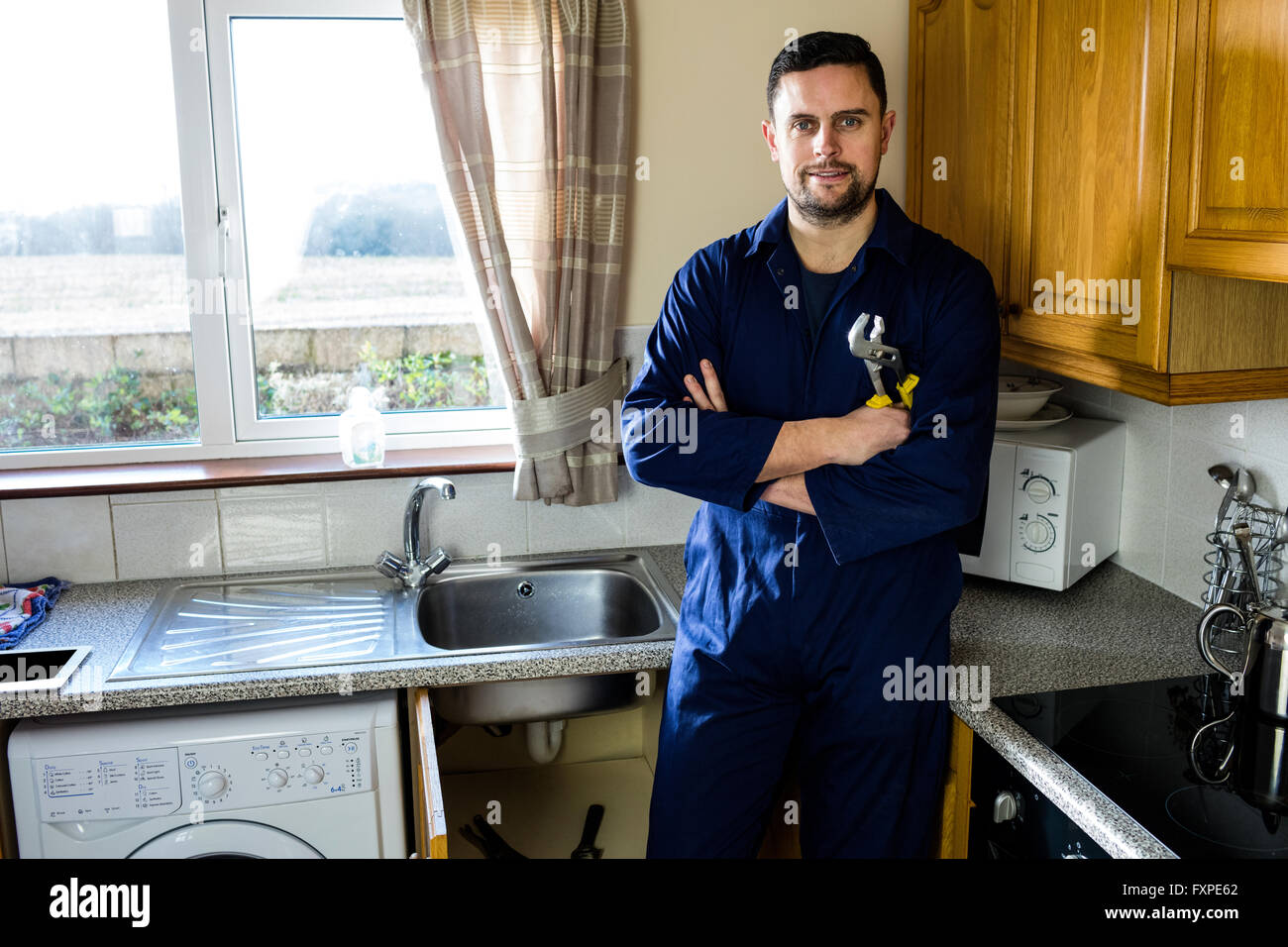 Portrait of plumber standing in kitchen Stock Photo - Alamy